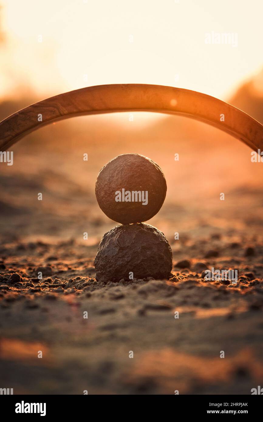 Vertical shot of rock balls under the half Moon shaped woods with a ...