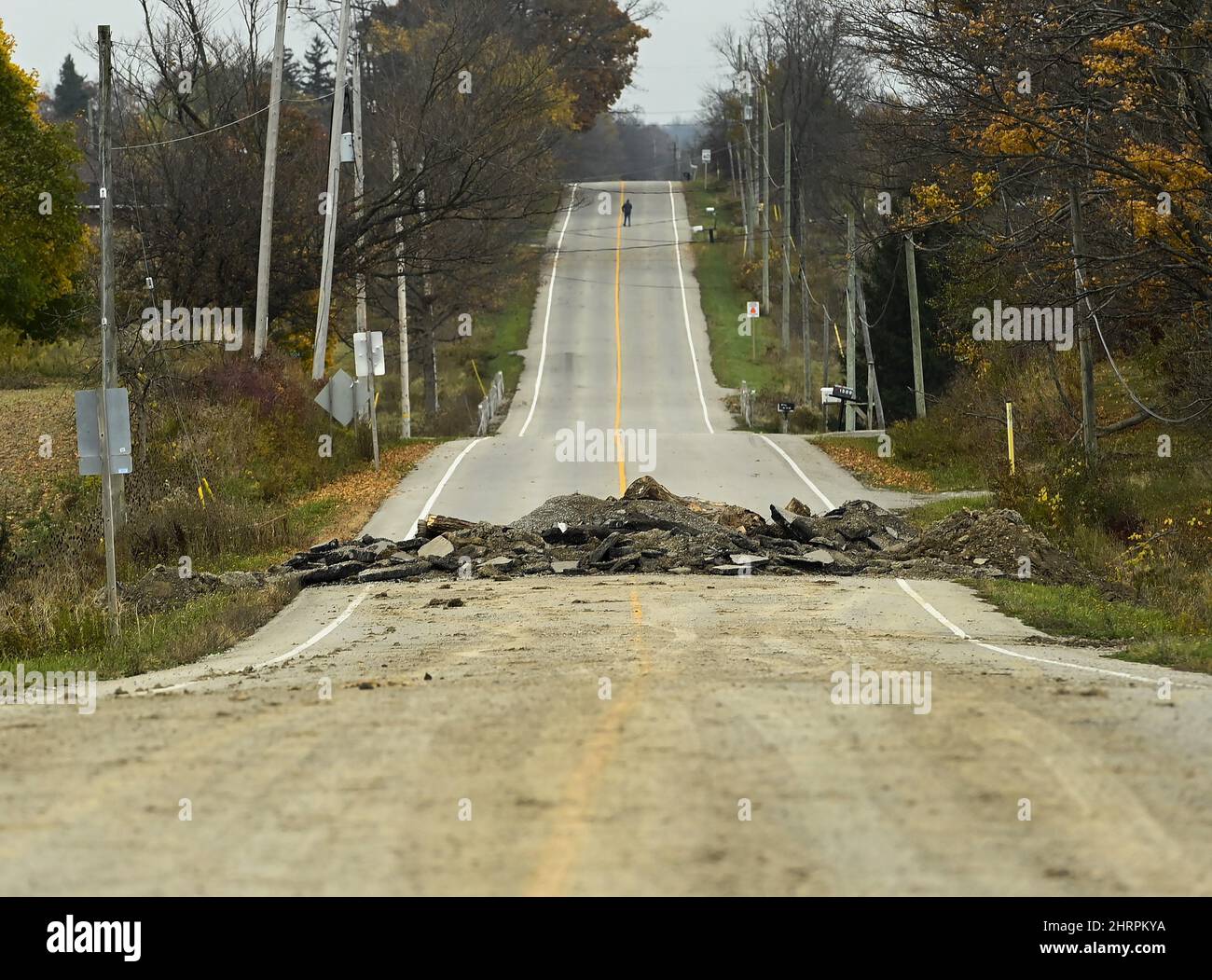 A road leading into a housing development is dug up blocking one of the ...