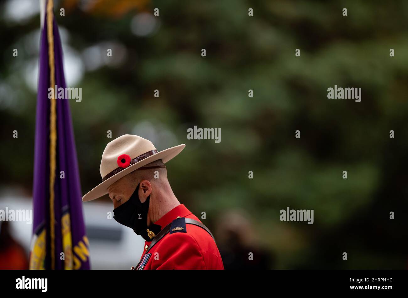 An RCMP officer in red serge sports a poppy on his stetson and wears a ...