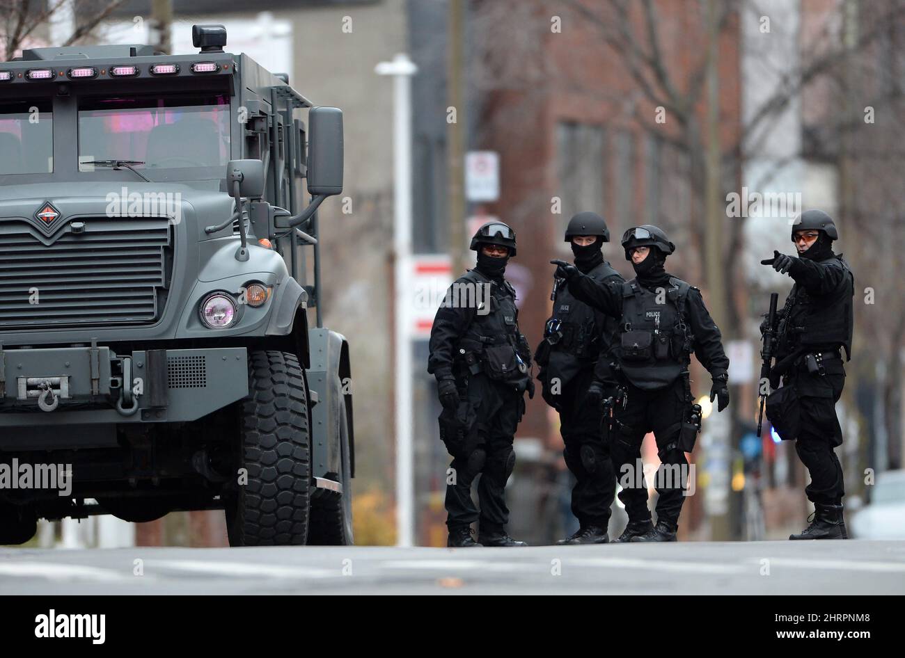 Police tactical team members assemble near an armoured vehicle at the ...