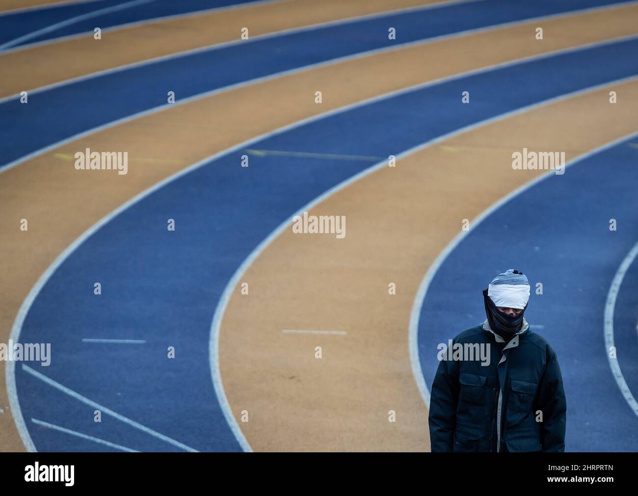 A man wearing a face mask to curb the spread of COVID-19 walks laps on ...