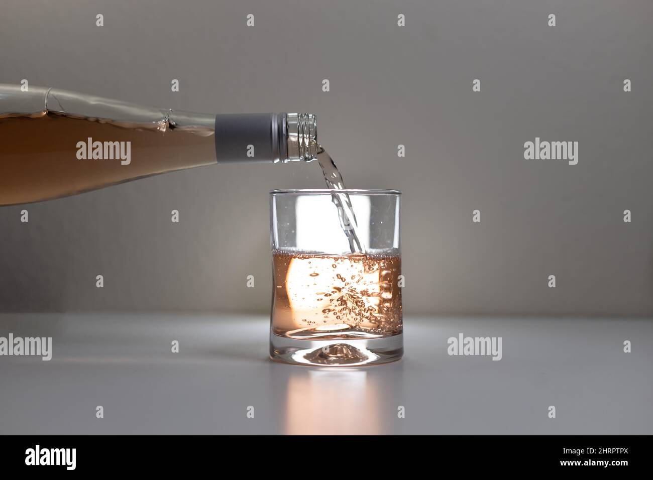 Bottle pouring light brown drink in a glass on a white background Stock ...