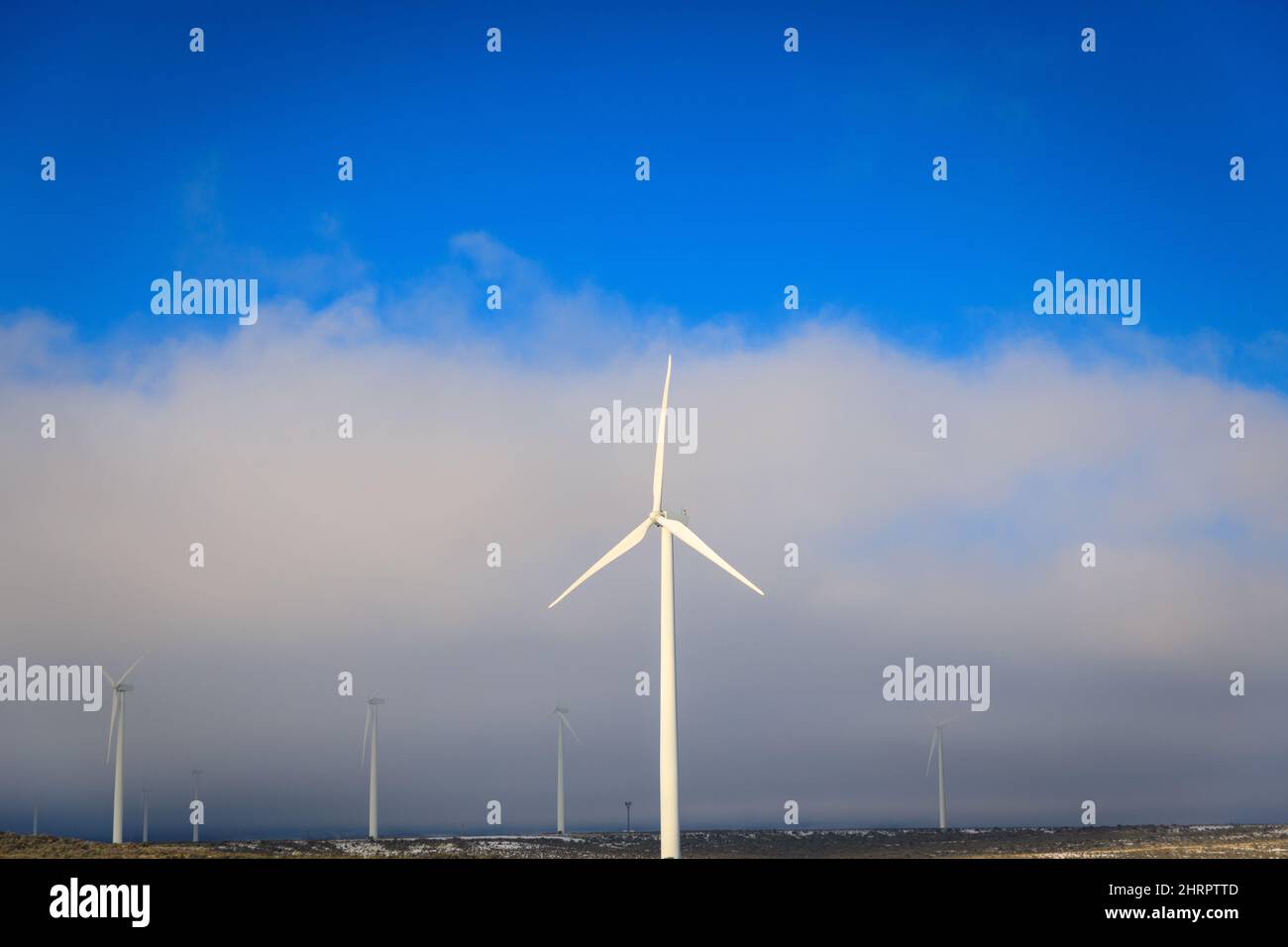 Aerial view of a wind turbine with the background of clouds under blue ...