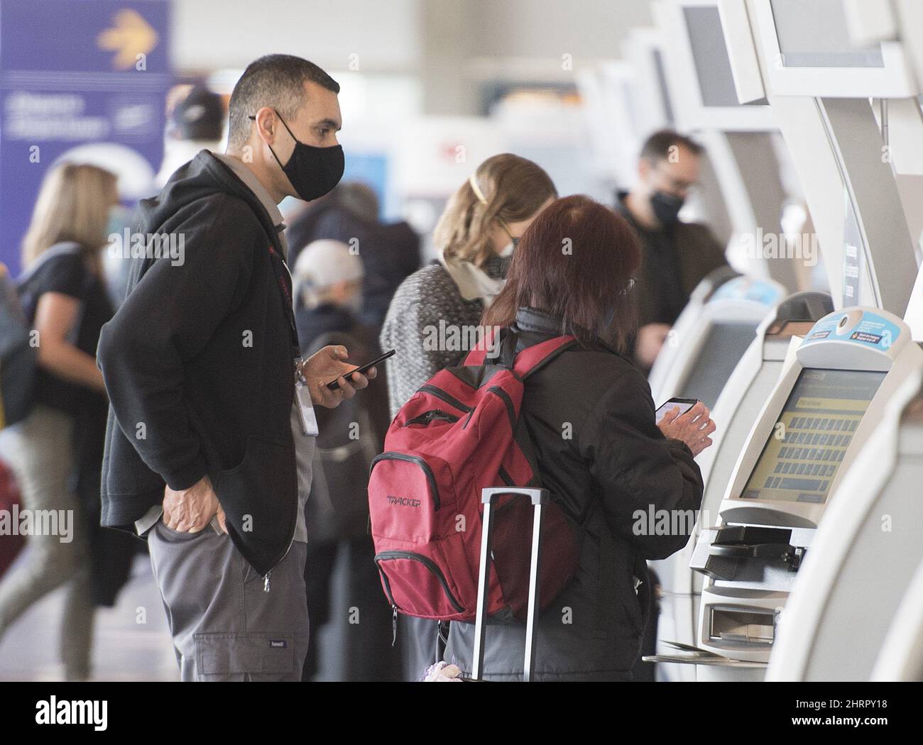 Passengers check-in using self-service desks at MontrÃ©alâ€“Trudeau International Airport in ...