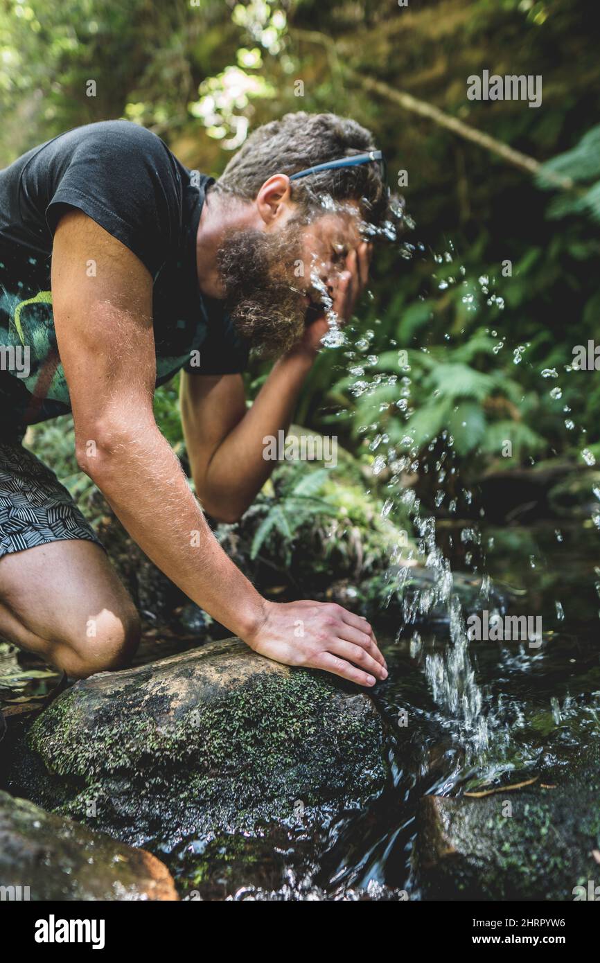 Male drinking water from a stream Stock Photo - Alamy