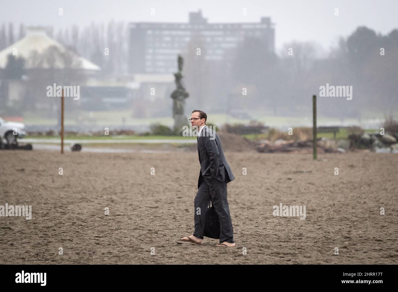 Jason Rude wears a suit and tie as he walks across the sand at English ...