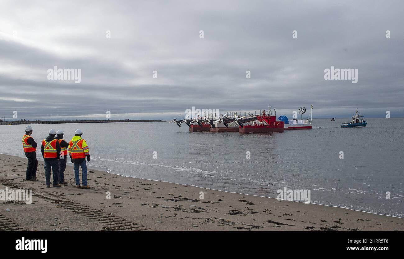 Employees of Sustainable Marine watch as a large floating tidal energy ...