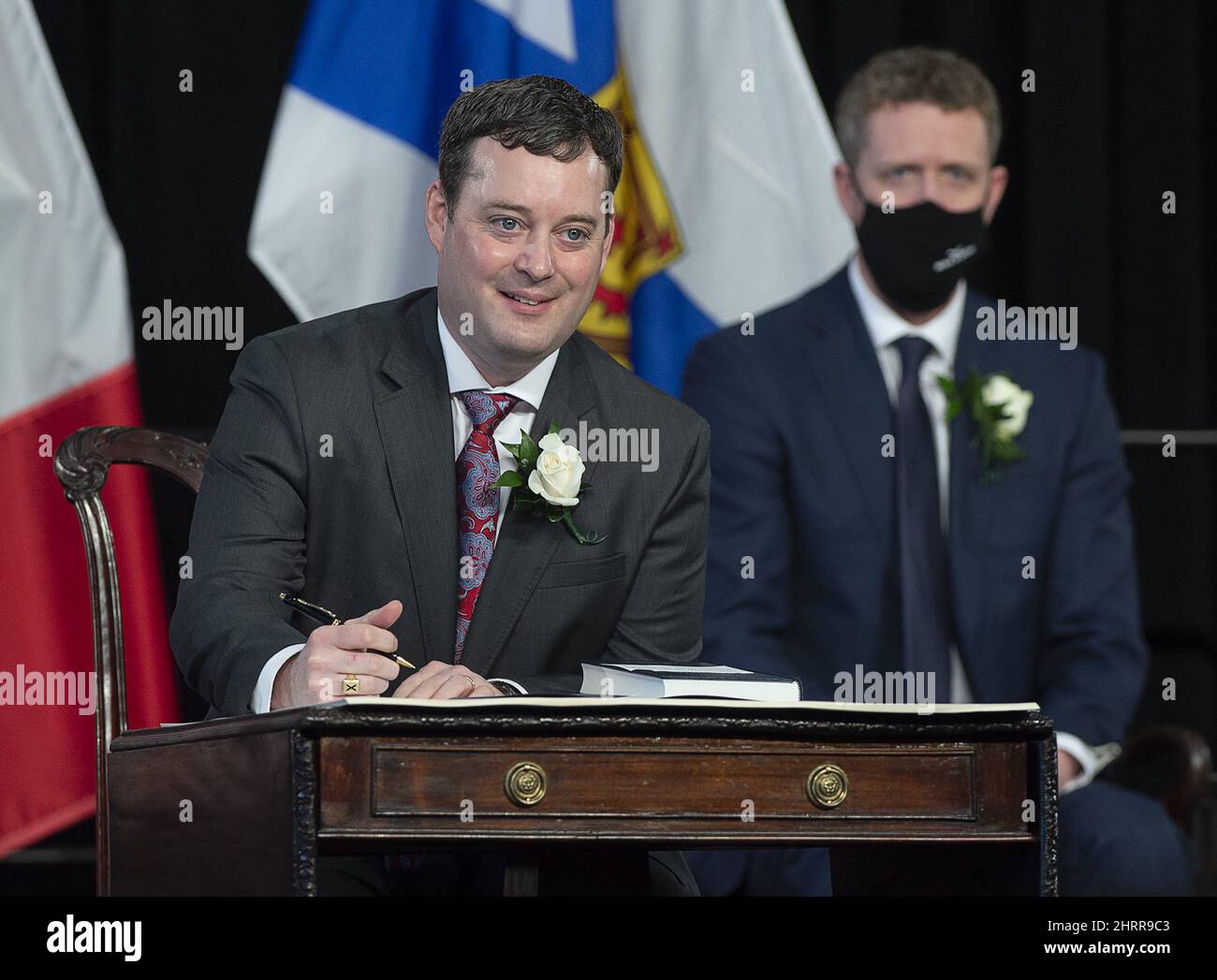 Nova Scotia Premier Iain Rankin, right, looks on as Randy Delorey signs ...