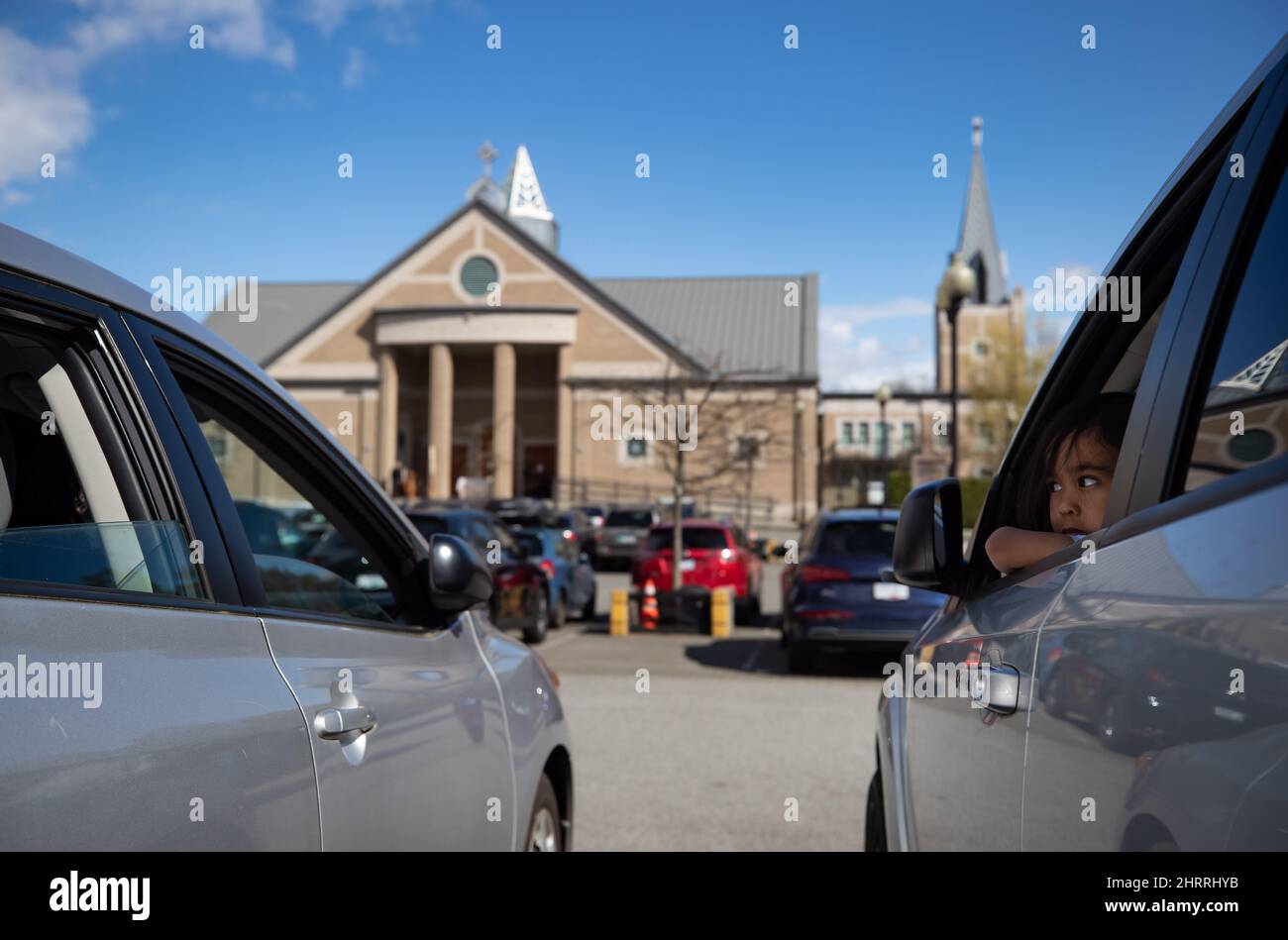 A young girl sits in a vehicle as parishioners attend an outdoor Easter ...