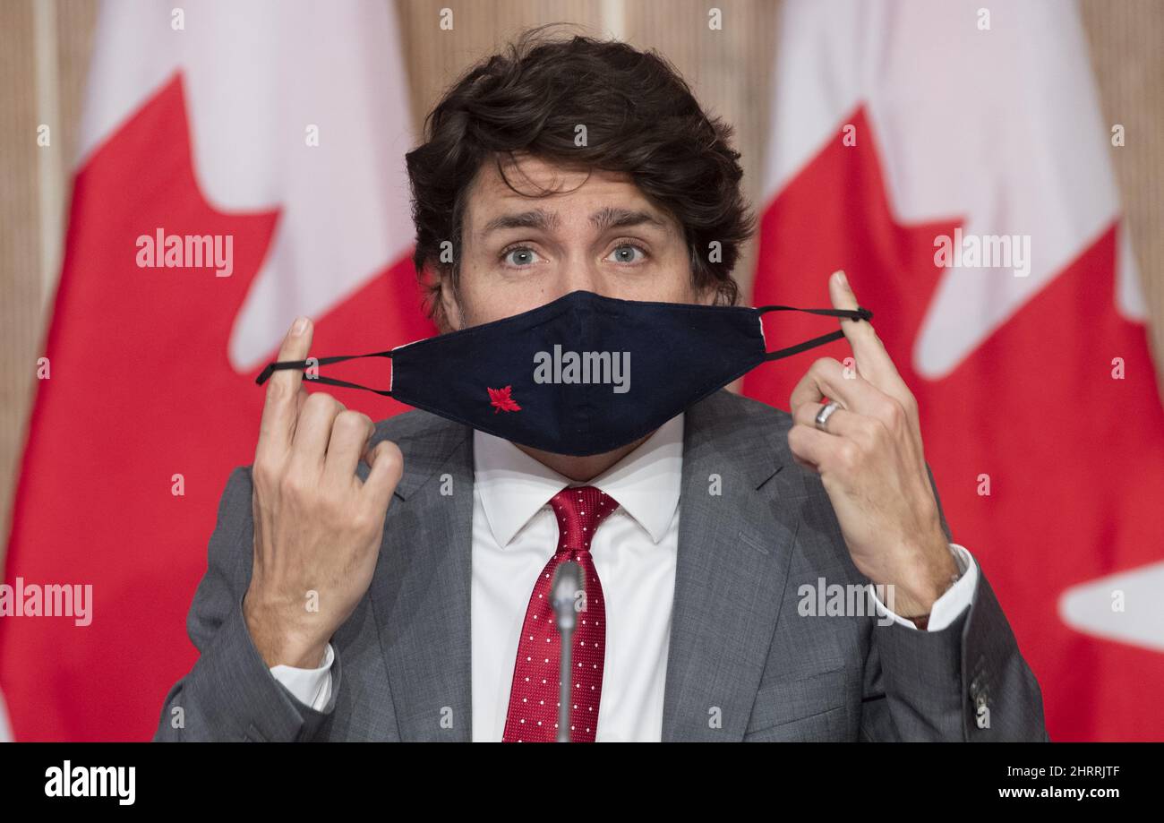 Prime Minister Justin Trudeau removes his mask as he arrives at a news ...