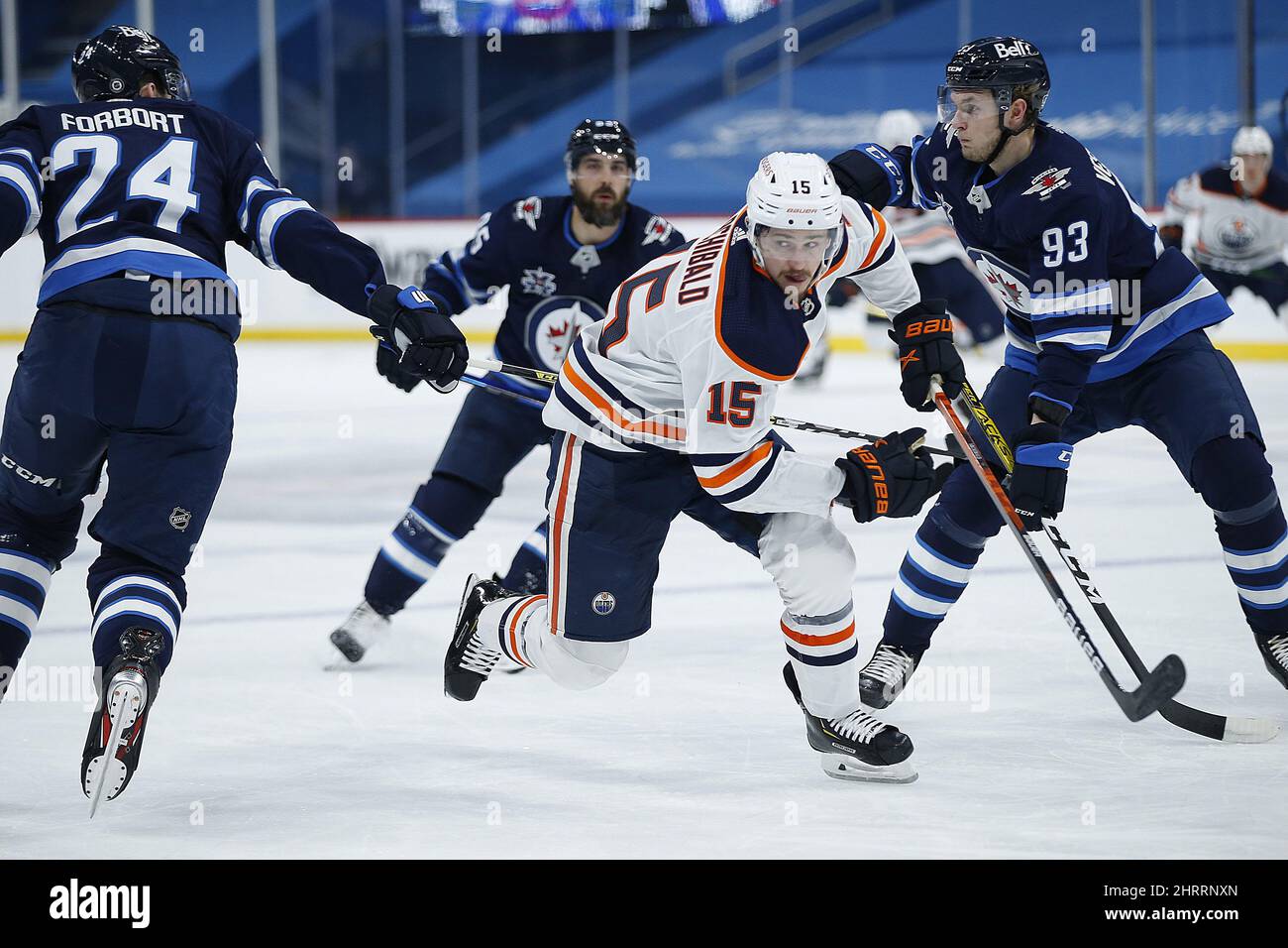 Edmonton Oilers' Josh Archibald (15) skates between Winnipeg Jets ...