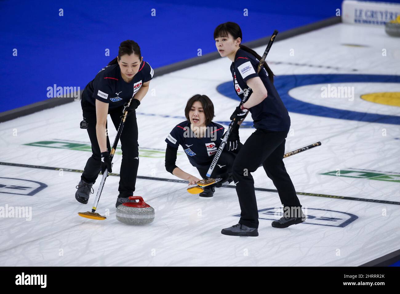 Japan skip Sayaka Yoshimura, centre, makes a shot as third Kaho Onodera ...