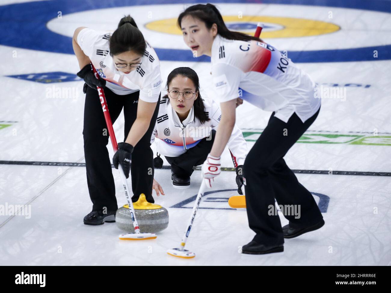 South Korea skip Eun-Jung Kim, centre, makes a shot as second Chohi Kim ...