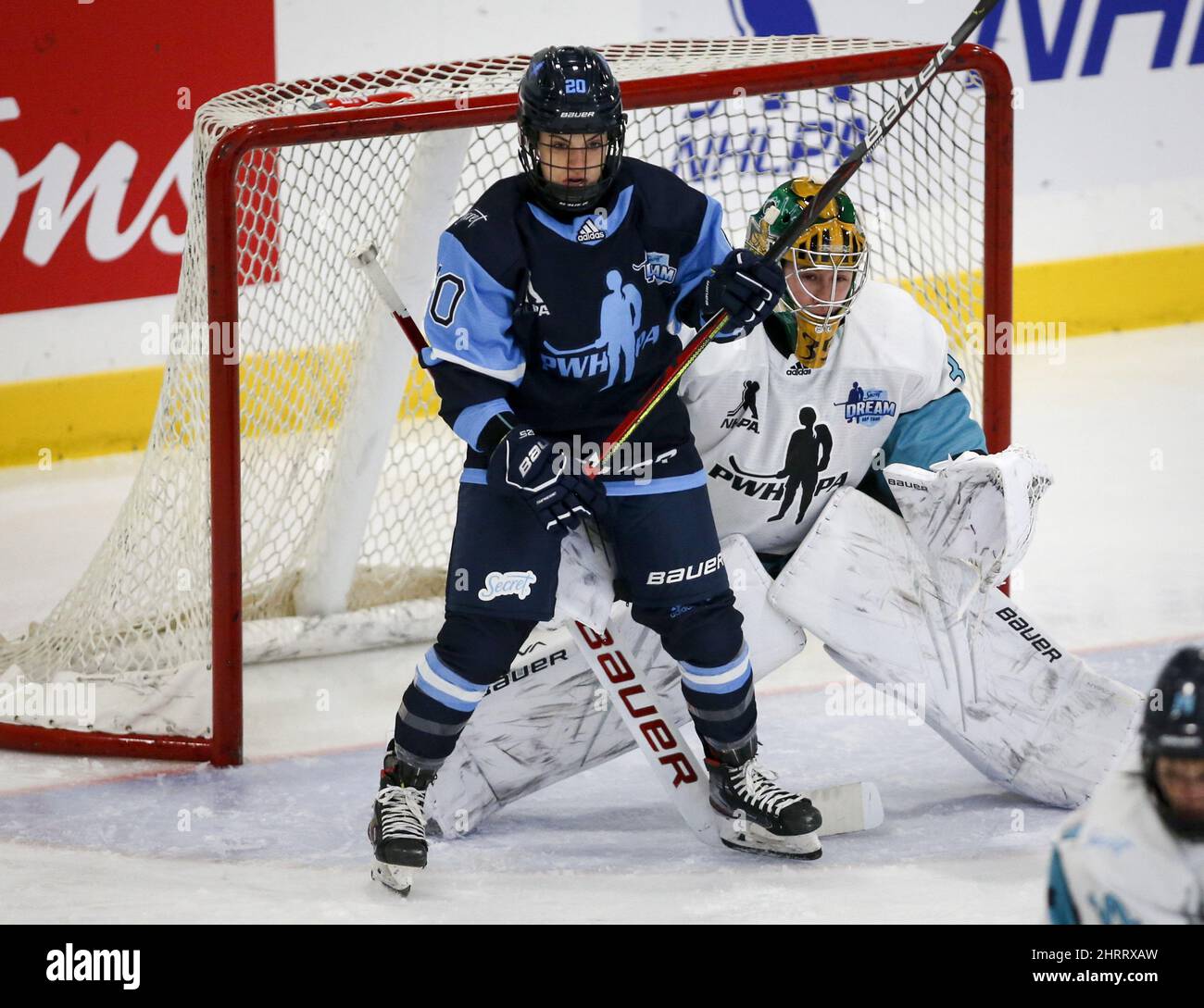 Team Bauer Kristin O'Neill, left, blocks Team Sonnet goalie Shea Tiley ...