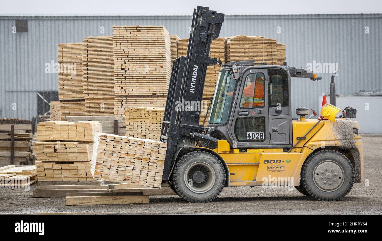A worker moves lumber at the Spray Lake Sawmills in Cochrane, Alta ...