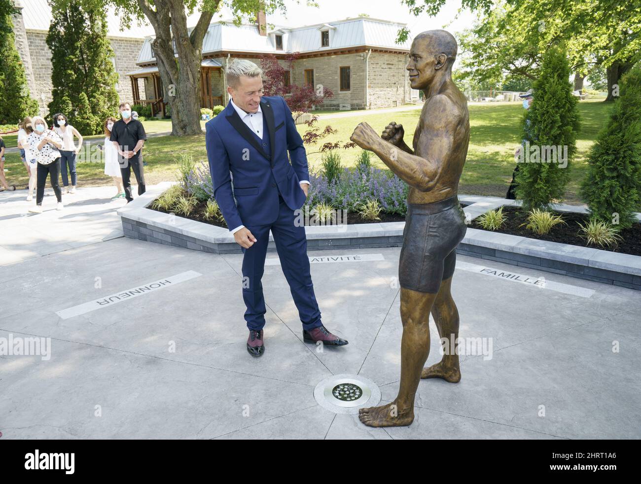 Mixed martial arts champion Georges St-Pierre looks at a bronze statue ...
