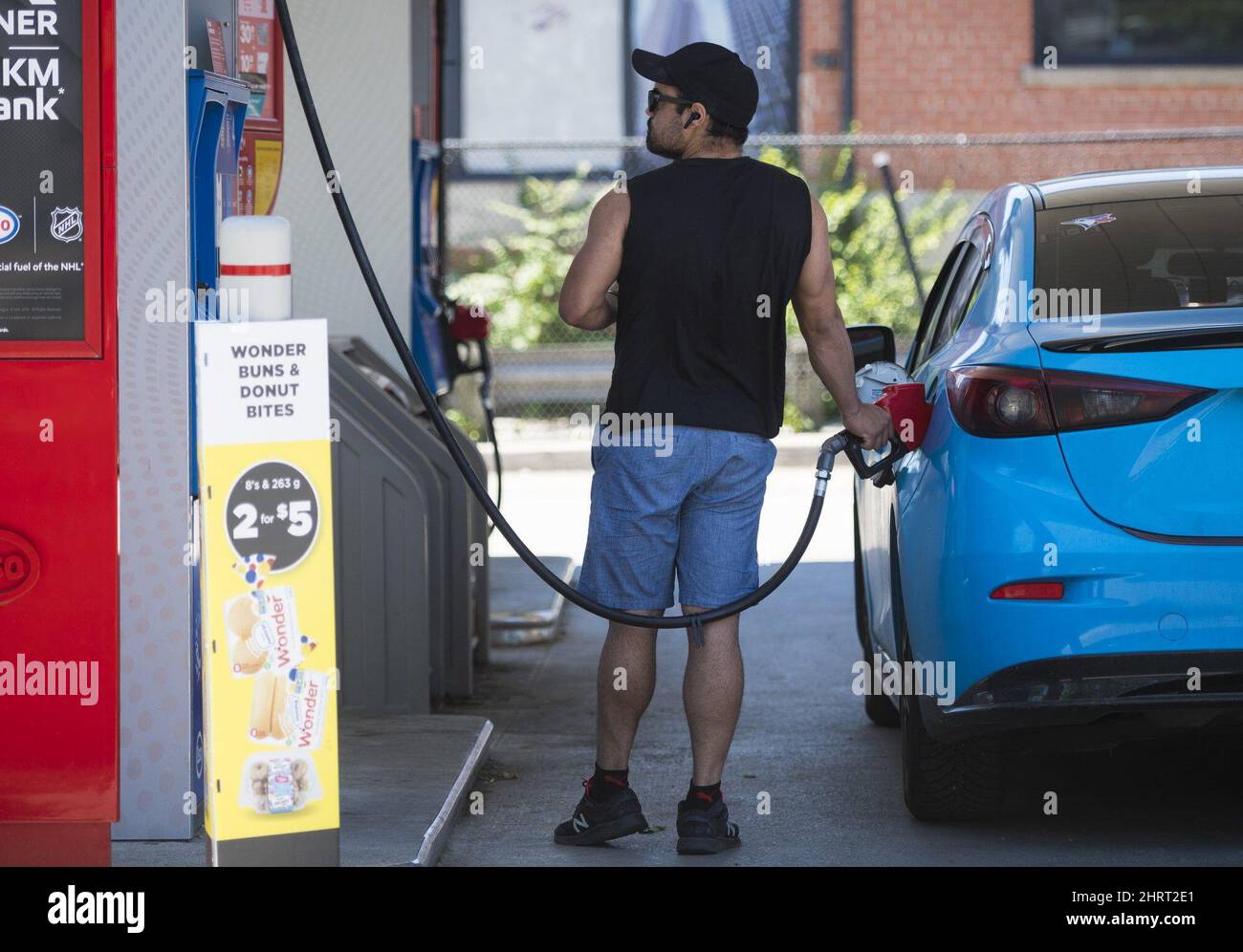 A commuter pumps gas into their vehicle at a Esso gas station in ...
