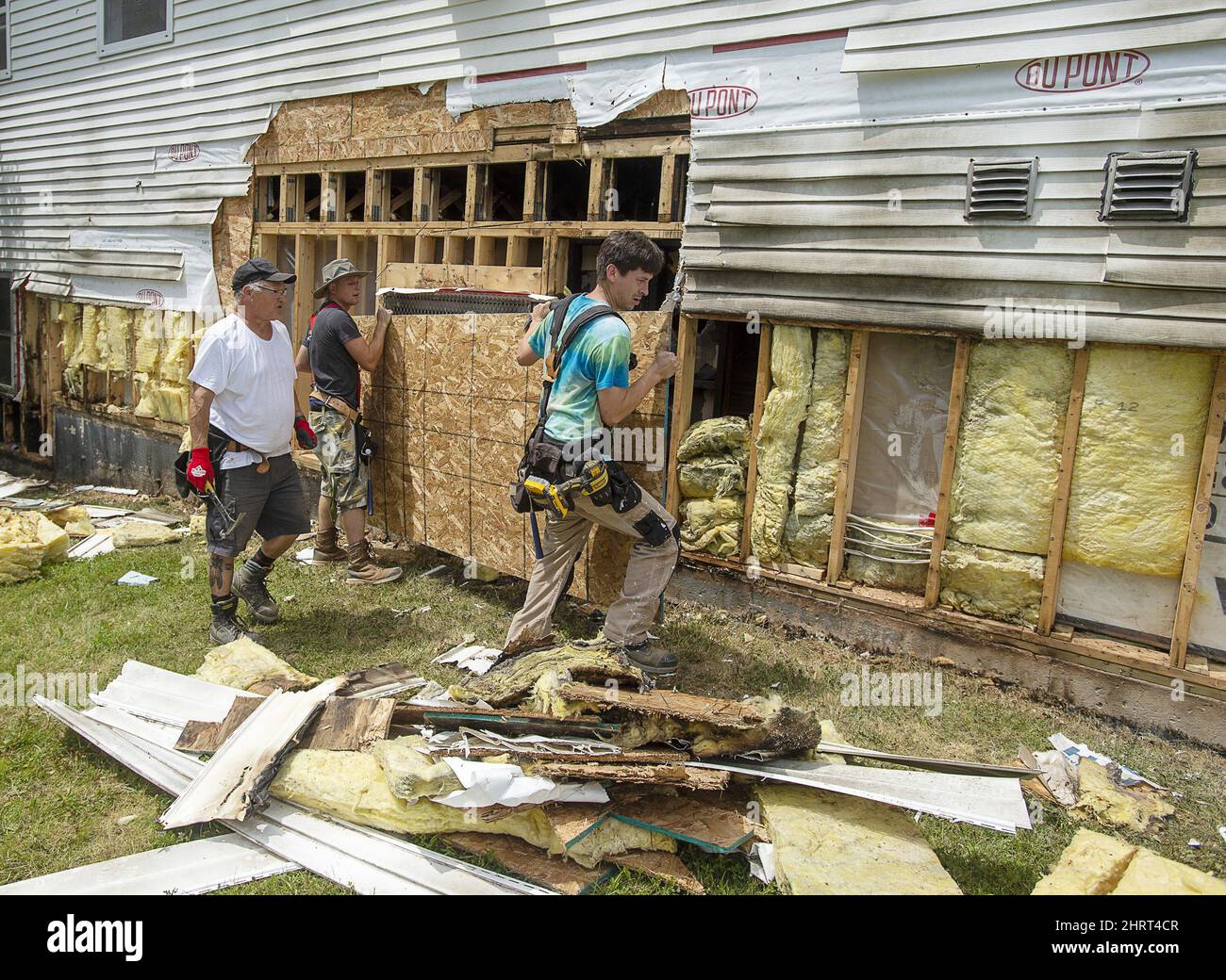 Workers cover damaged siding after a fire at St. Kateri Tekakwitha ...