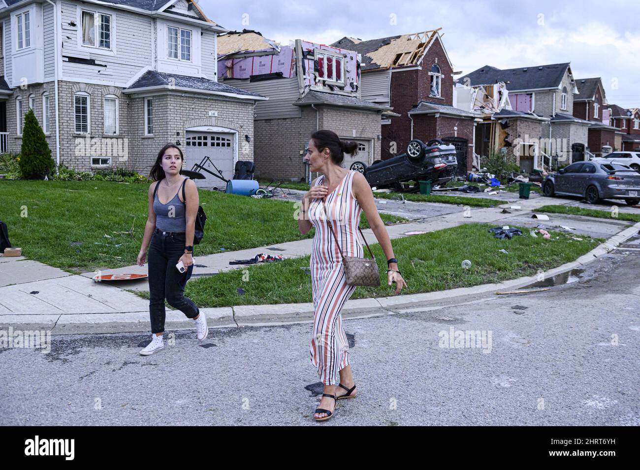 Residents leave their homes after a tornado caused significant damage ...
