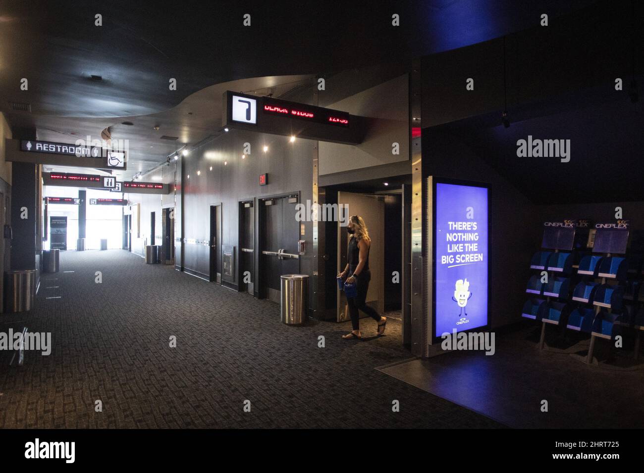 A moviegoer steps out of an auditorium at a Cineplex Movie Theatre ...