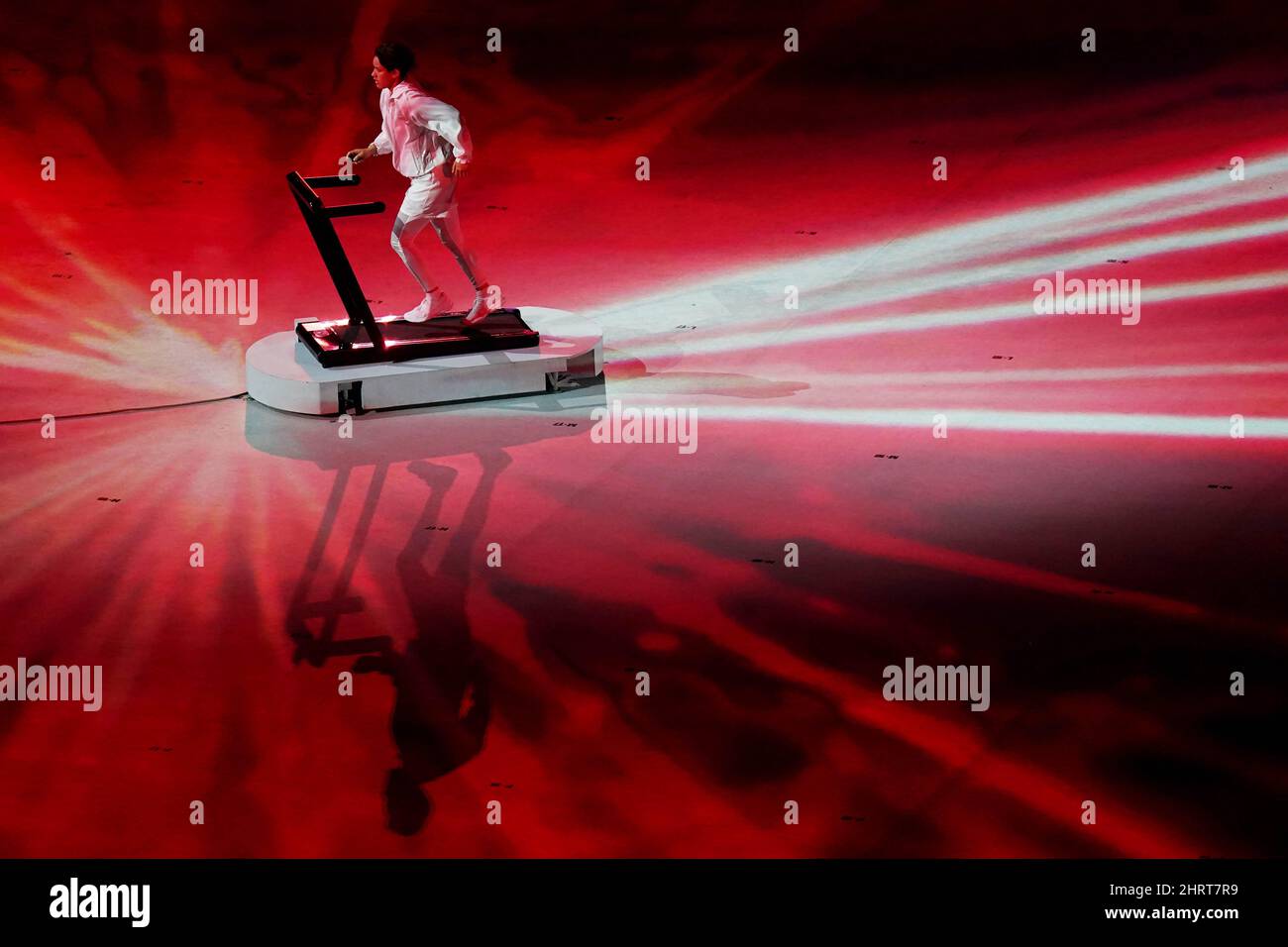 A runner runs on a treadmill while performing in the opening ceremonies ...
