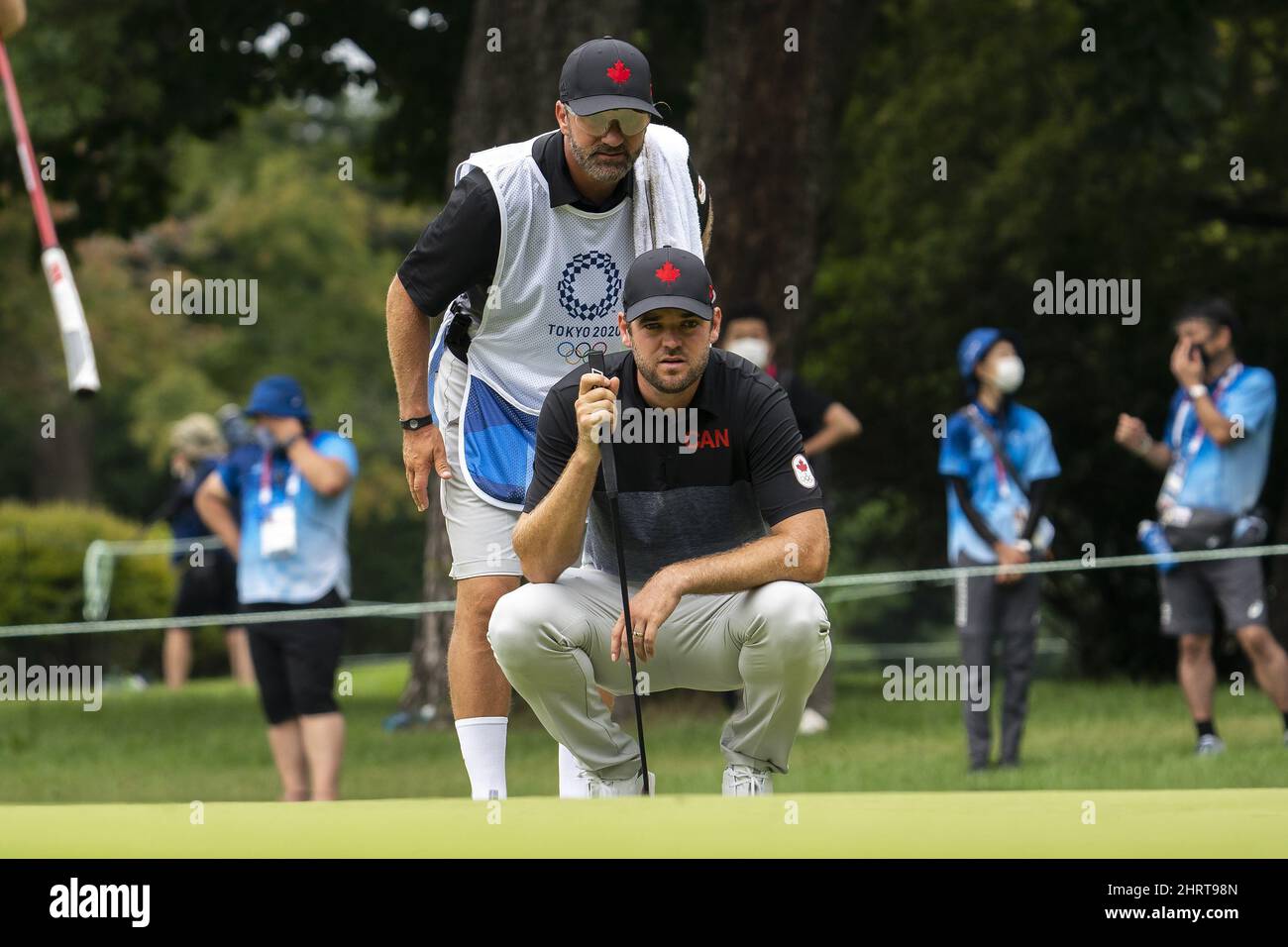 Canada's Corey Conners and caddy Danny Sahl line up a putt on the sixth ...