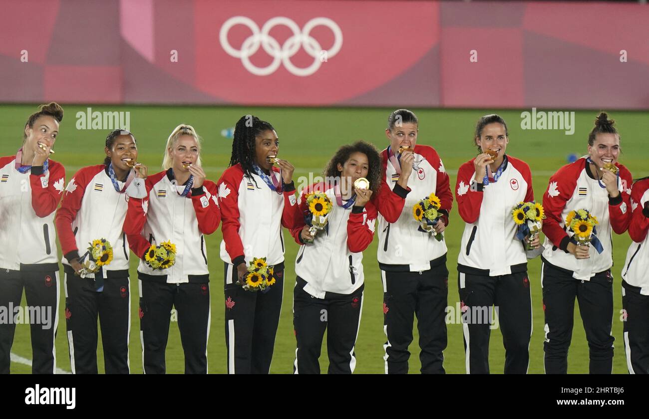 Canadian soccer players bite their medals as they celebrate on the ...
