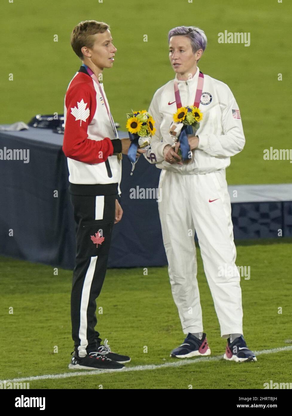 Canadian midfielder Quinn (left) talks with Megan Rapinoe of the USA at ...