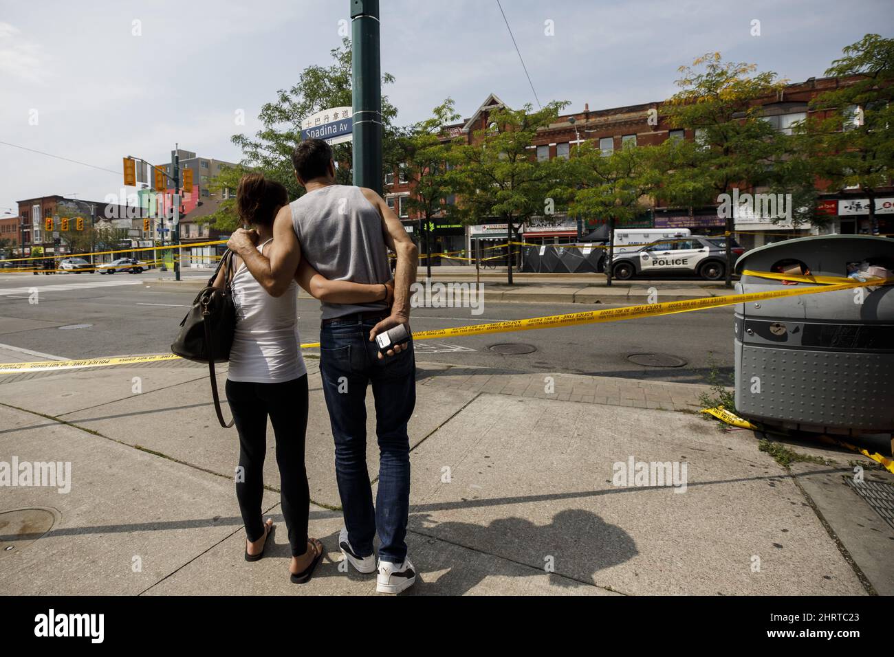 Passersby look in at a crime scene of a shooting that left two dead in ...