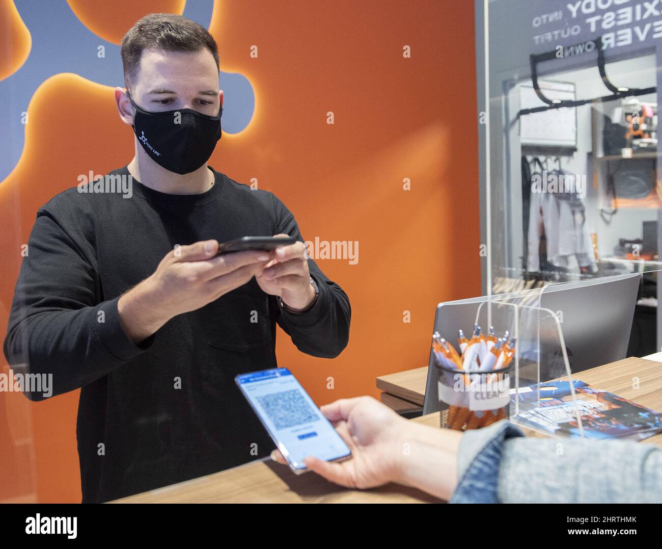 Jonathan Gagne, manager of Orangetheory Fitness, scans the COVID-19 QR ...