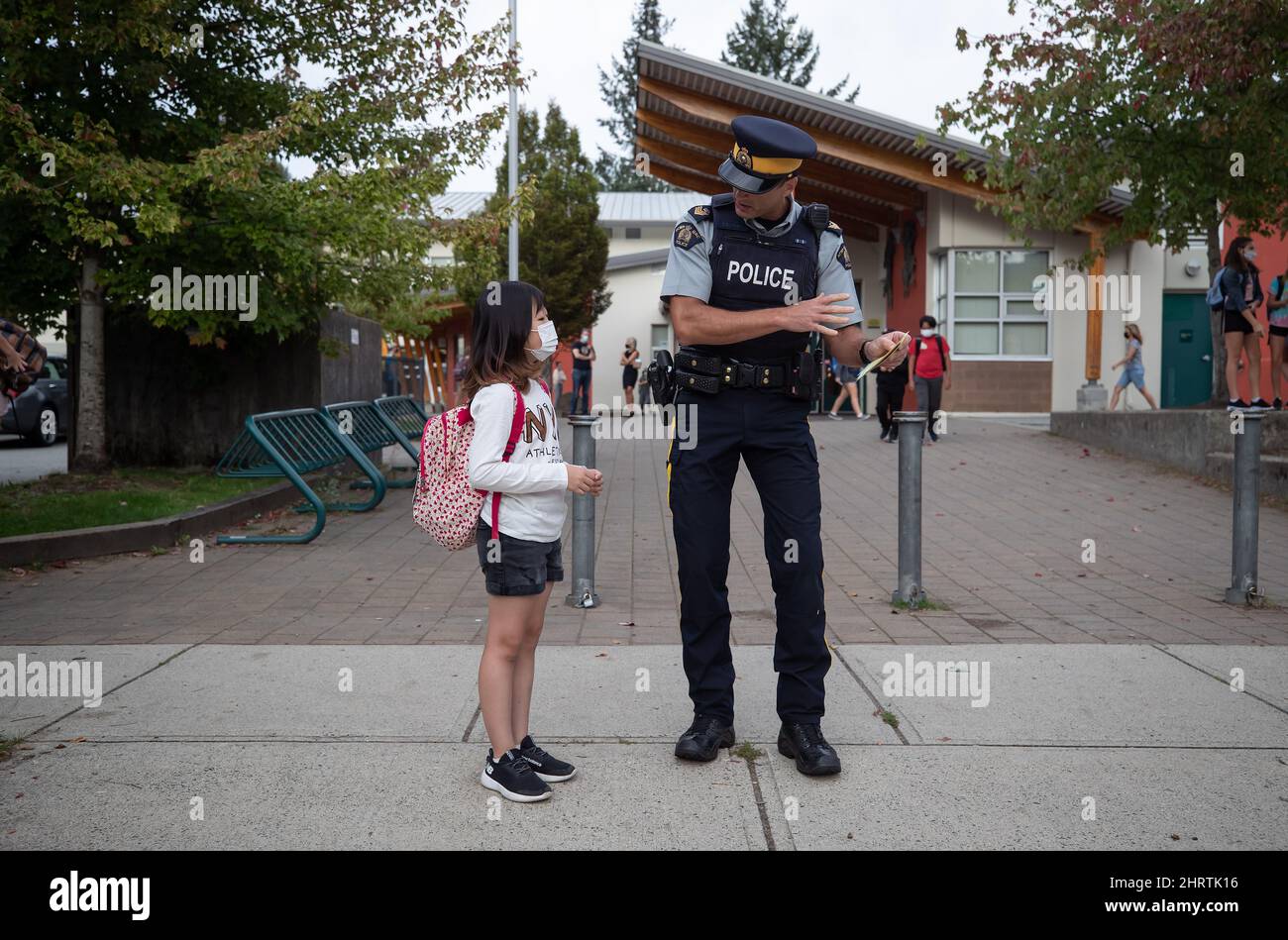 RCMP Sgt. Peter DeVries speaks with Grade 4 student Eva Kim, 9, outside ...