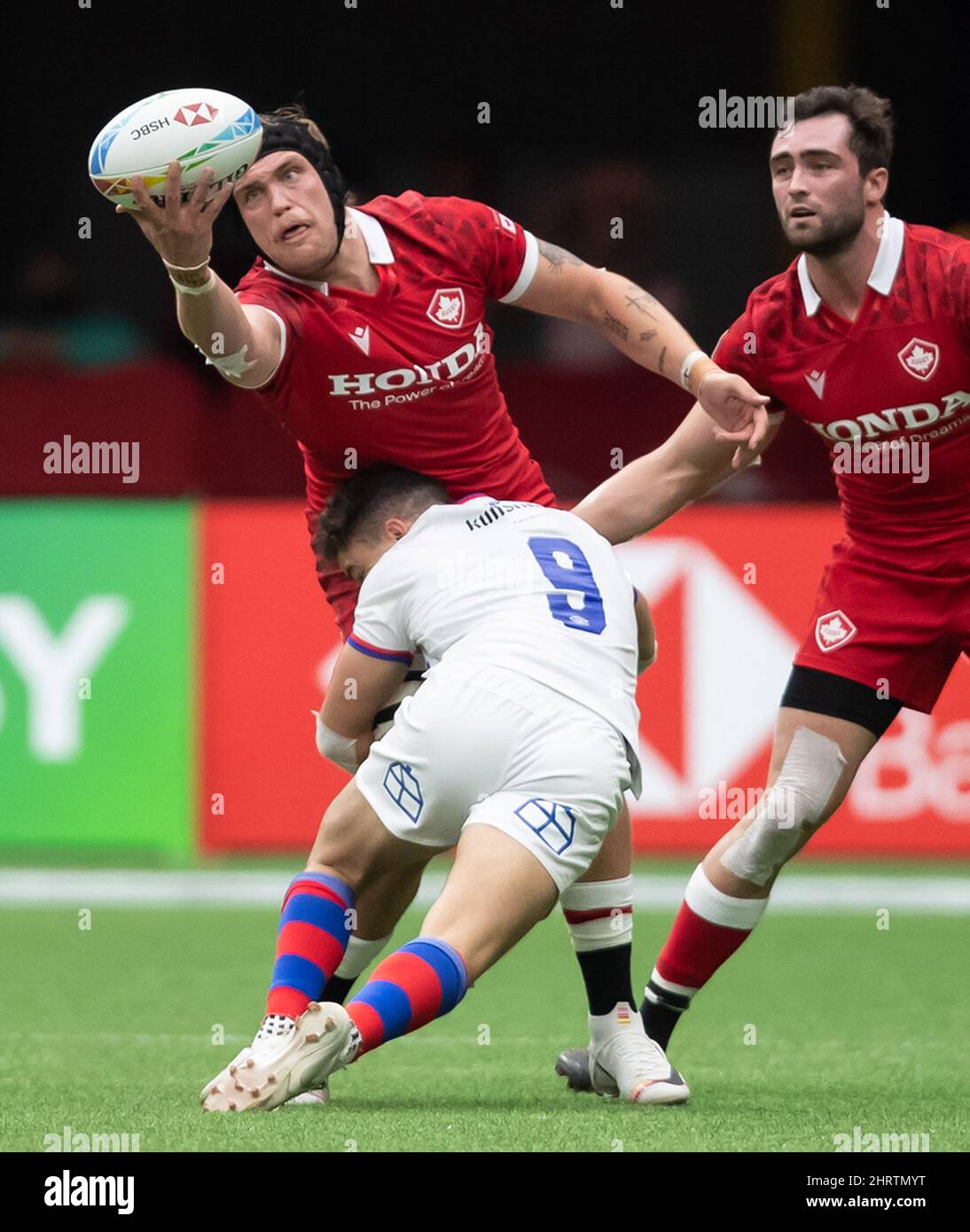 Canada's Jake Thiel, back, grabs the ball while being hit by Chile's ...