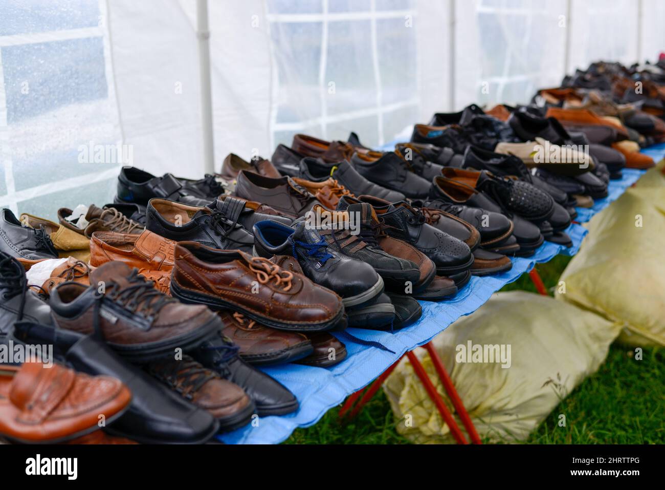 Closeup of a stack of different types of shoes on the tables covered ...