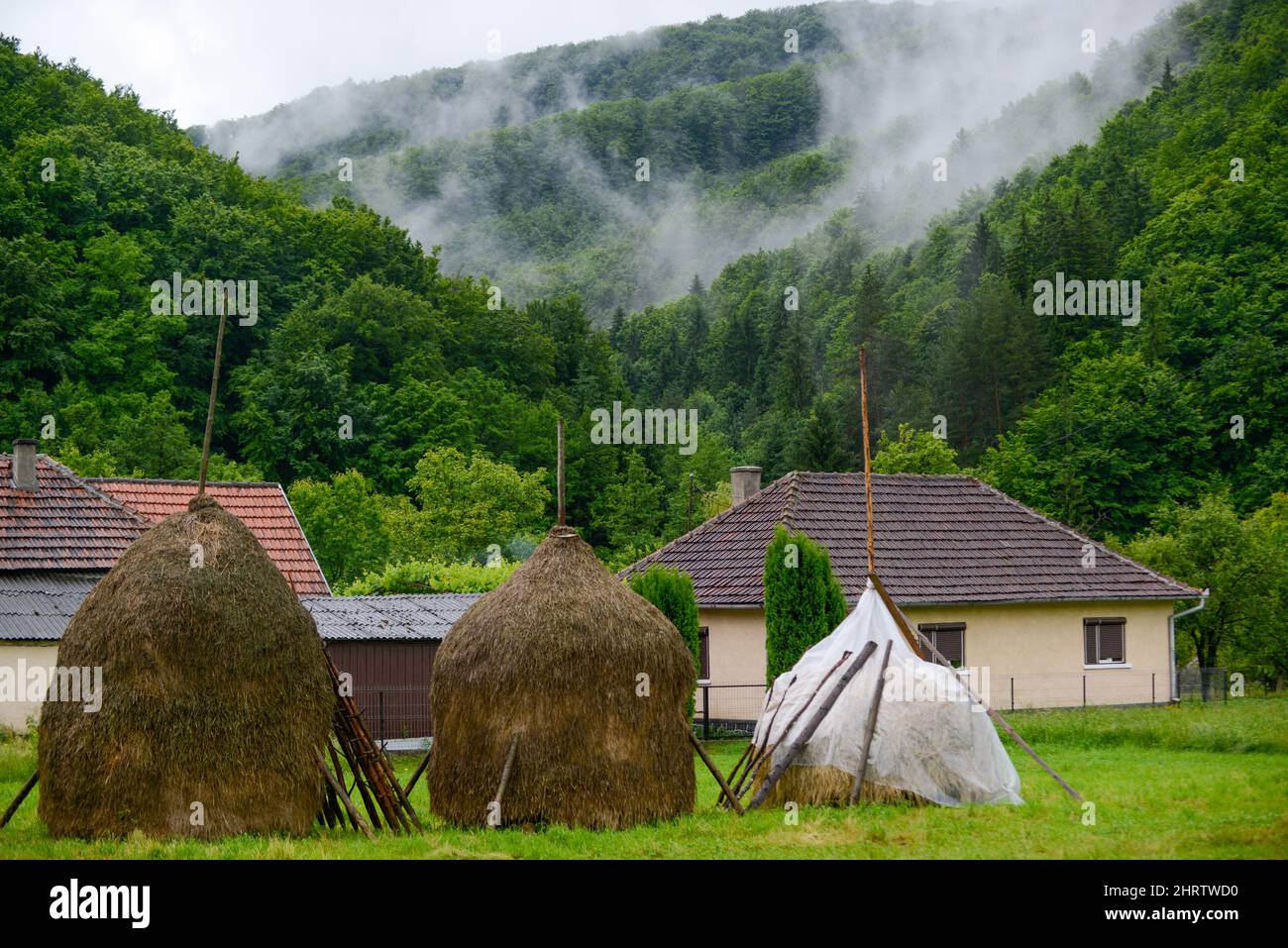 Beautiful view of a village with haystacks in the foreground and green ...