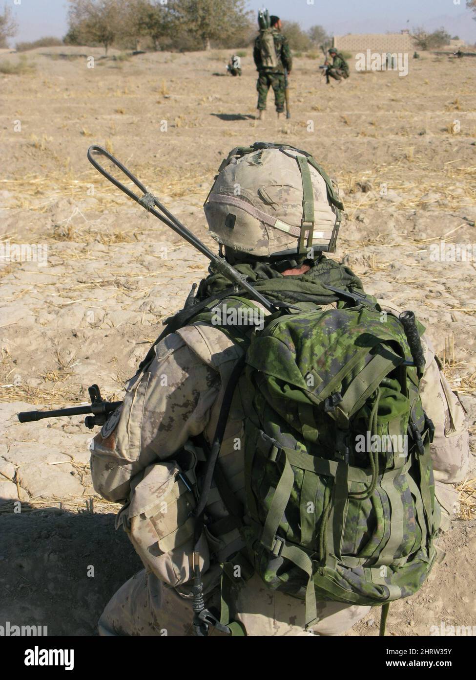 A Canadian soldier along with Afghan security forces patrols a village ...