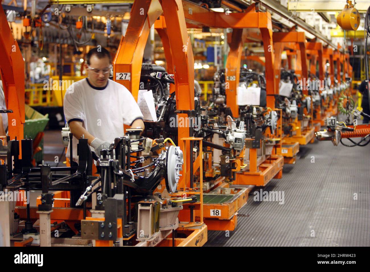 Employees work on the newest minivan version on the assembly line as ...