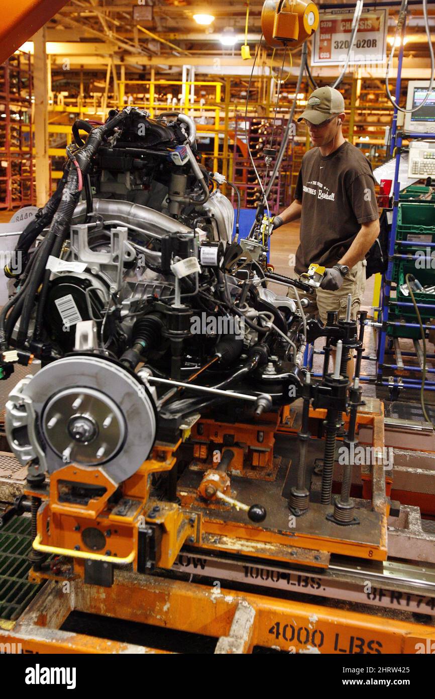 Employees work on the newest minivan version on the assembly line as ...