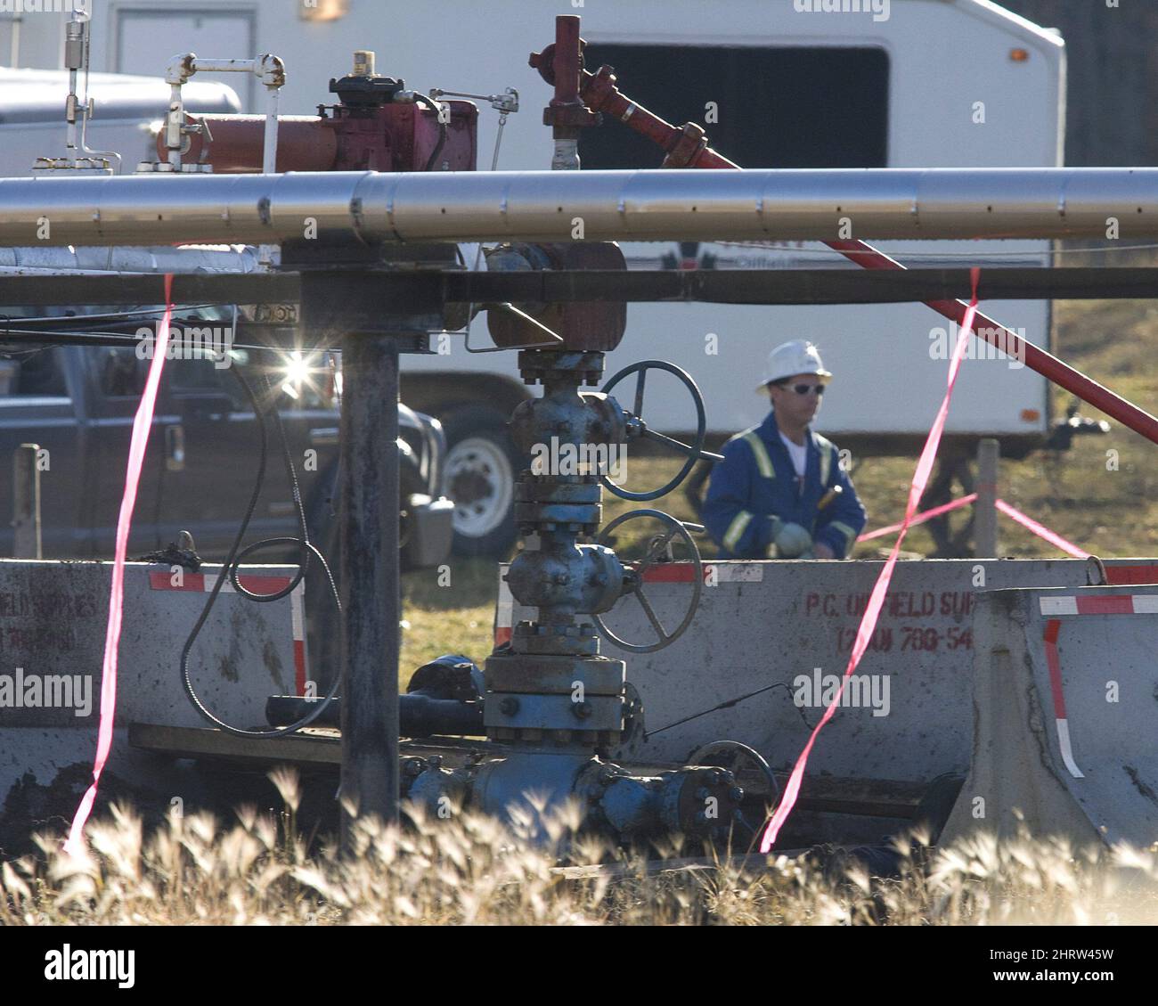 A EnCana employee can be seen behind the damaged natural gas wellhead ...