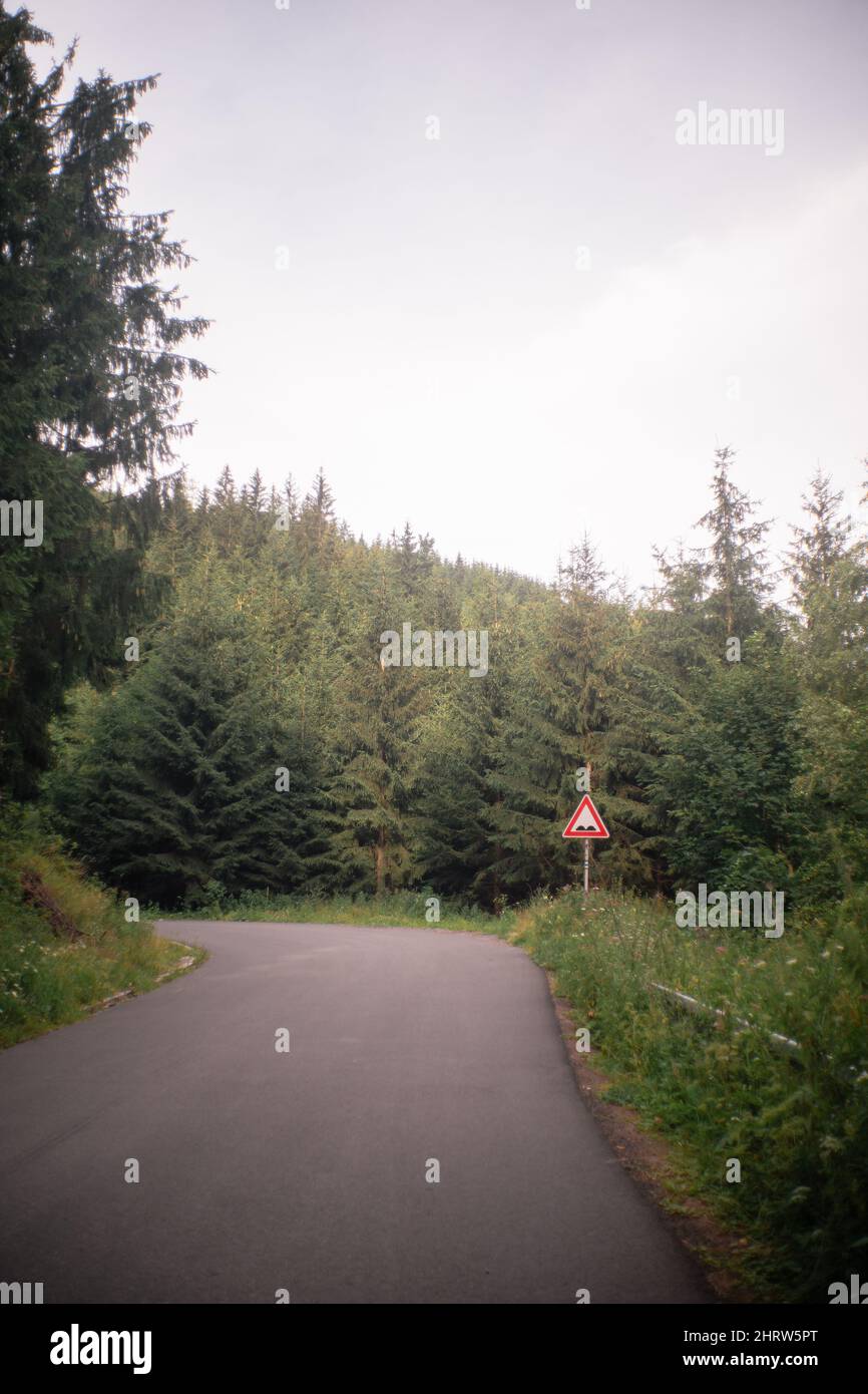 Eerie scenery of an empty road through a misty forest Stock Photo - Alamy