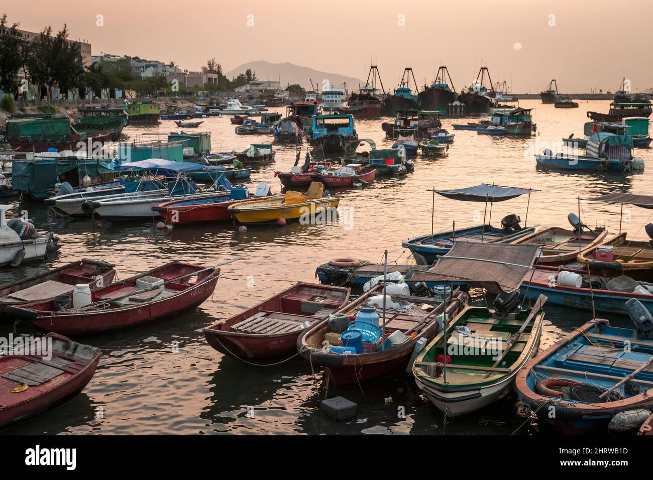 Local fishing boats at sunset at the waterfront of Cheung Chau, an ...