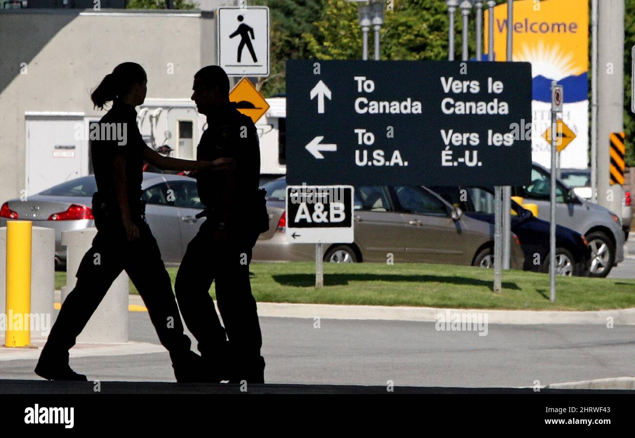 Canadian border guards are silhouetted as they replace each other at an ...