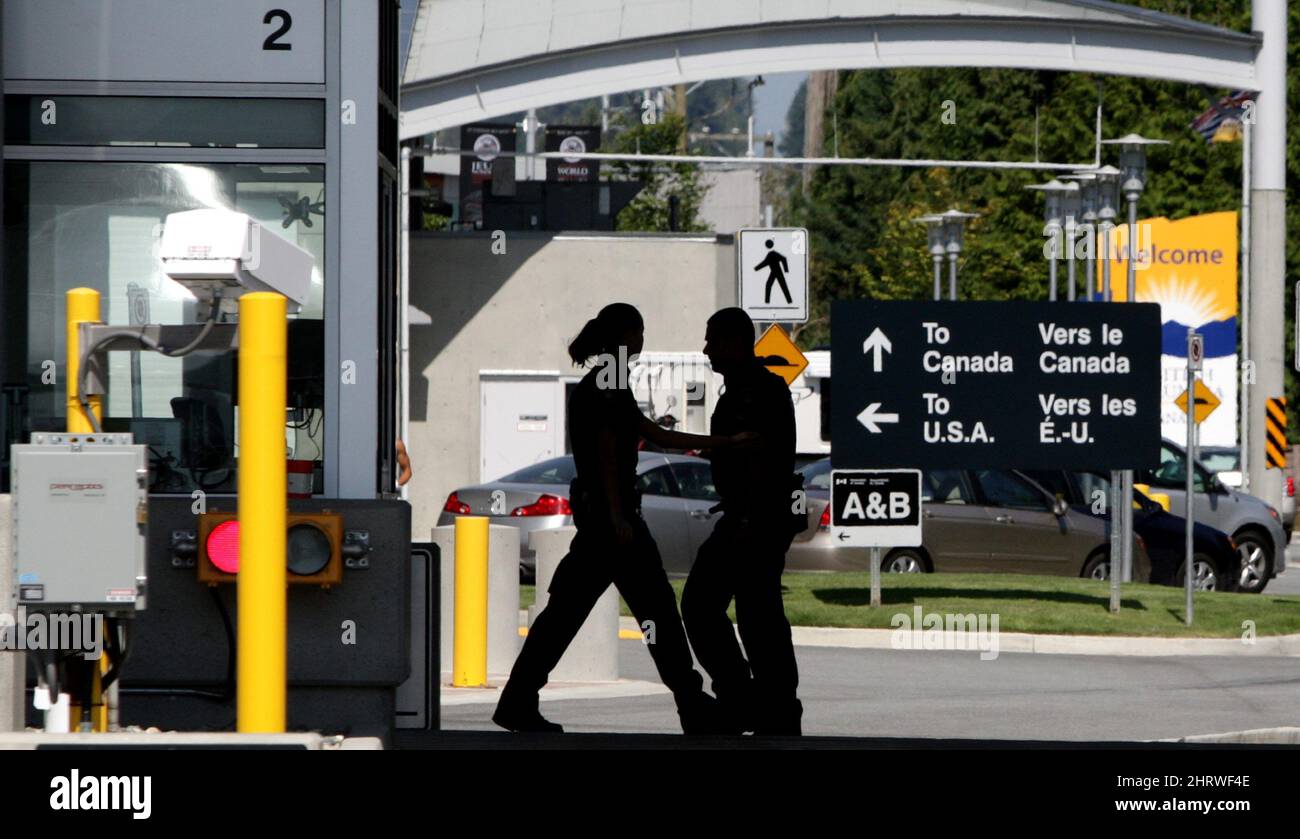 Canadian border guards are silhouetted as they replace each other at an ...