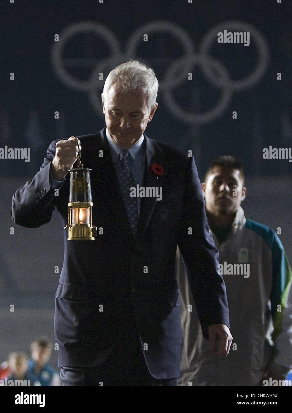 VANOC Chief Executive Officer John Furlong looks at the Olympic Flame ...