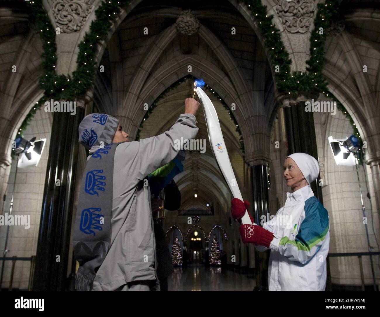 Lamplighter Martie Wyse (left) lights the Olympic torch for former ...