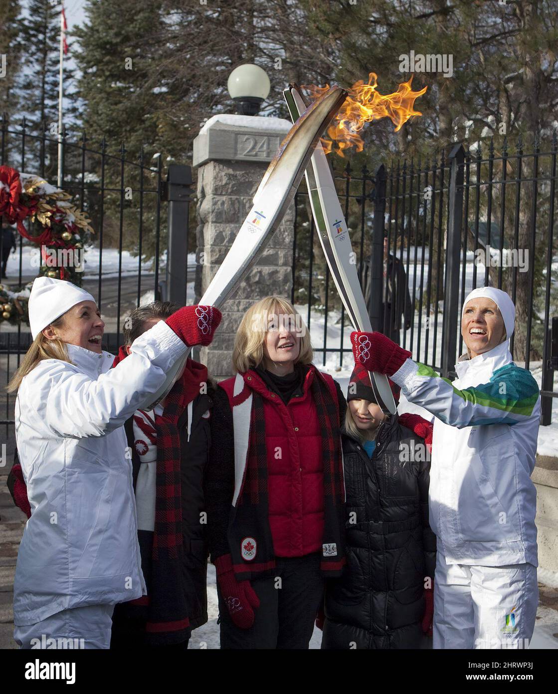 Kelly Murumets, left, hands over the Olympic Flame to Carolyn Waldo ...