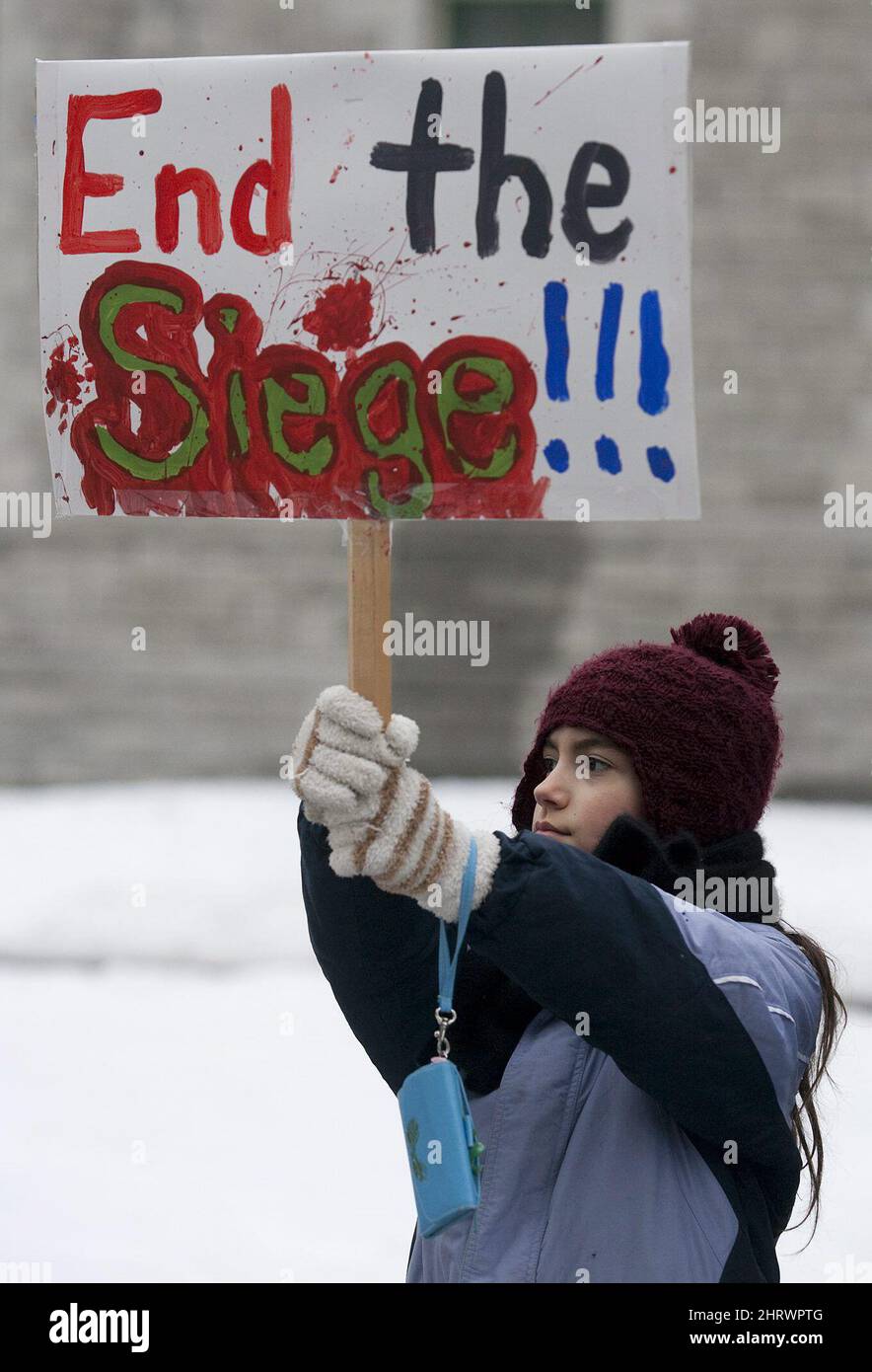 Allison MacIntyre, 8 holds up a sign calling for the end of the siege ...