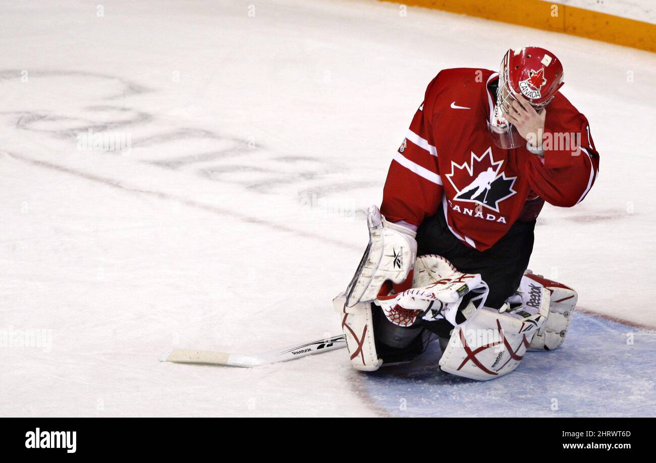 Team Canada goaltender Jake Allen fixes his face mask during a break in ...