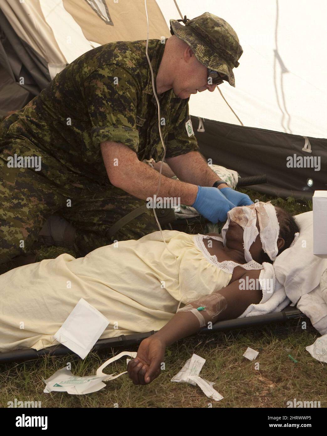 A Canadian Forces medic attends to an injured resident at a medical ...