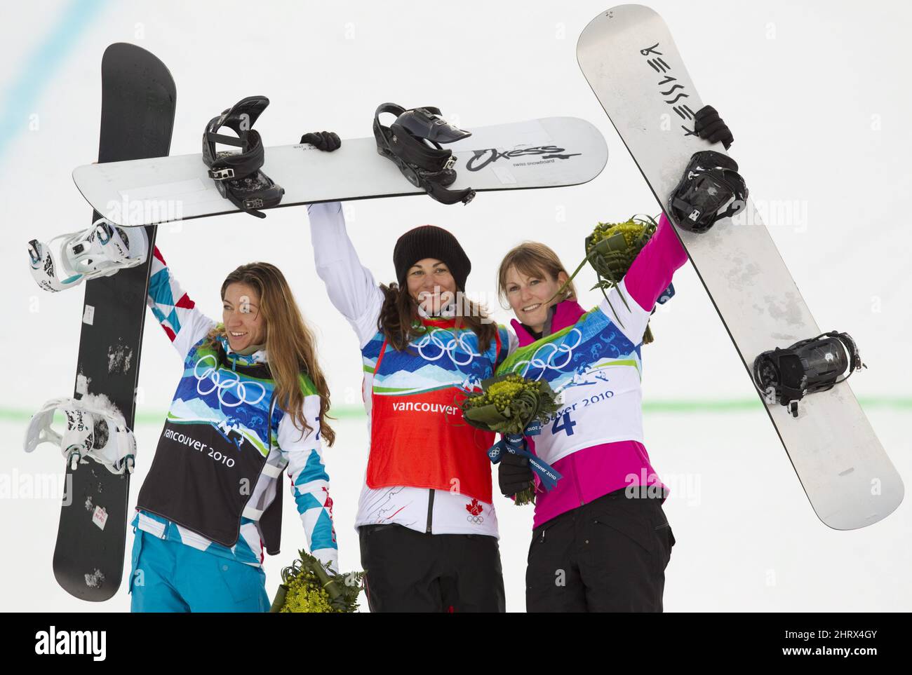 Maelle Ricker, centre, of Canada, makes a peace sign as she celebrates ...