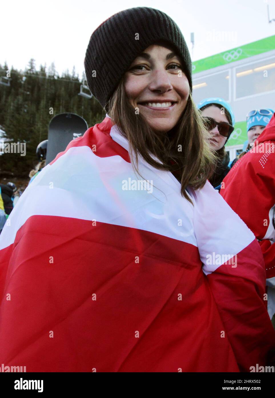 Maelle Ricker, of Canada, smiles while wrapped in the Canadian flag ...